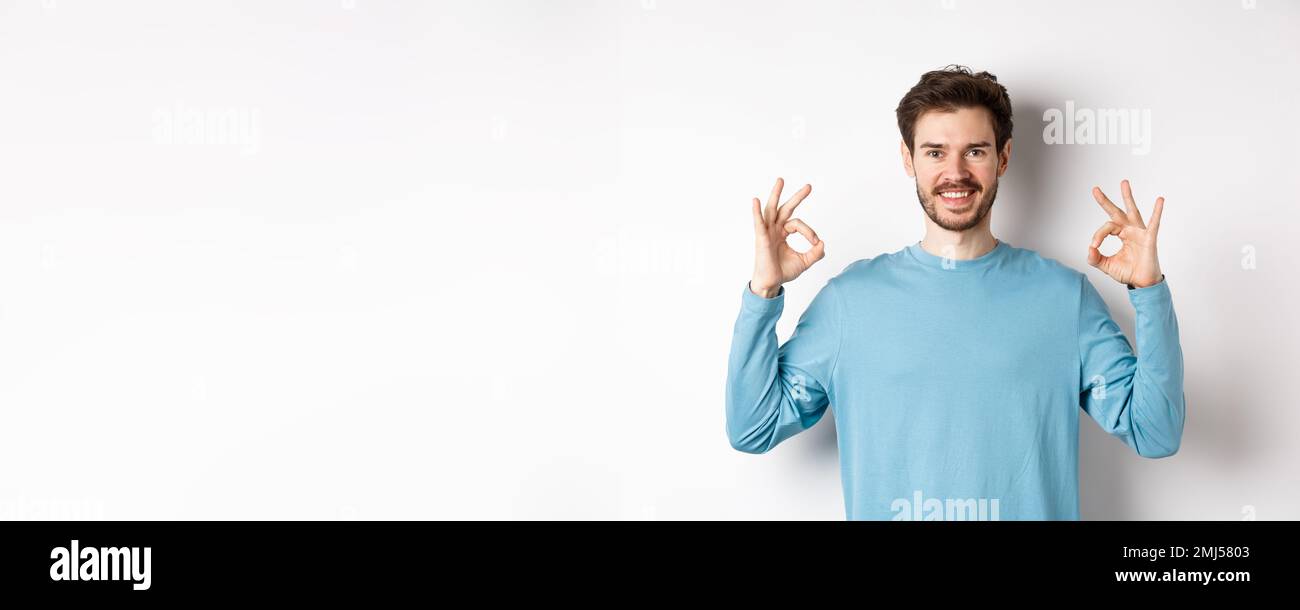 Very good. Smiling handsome guy showing okay signs and looking ...