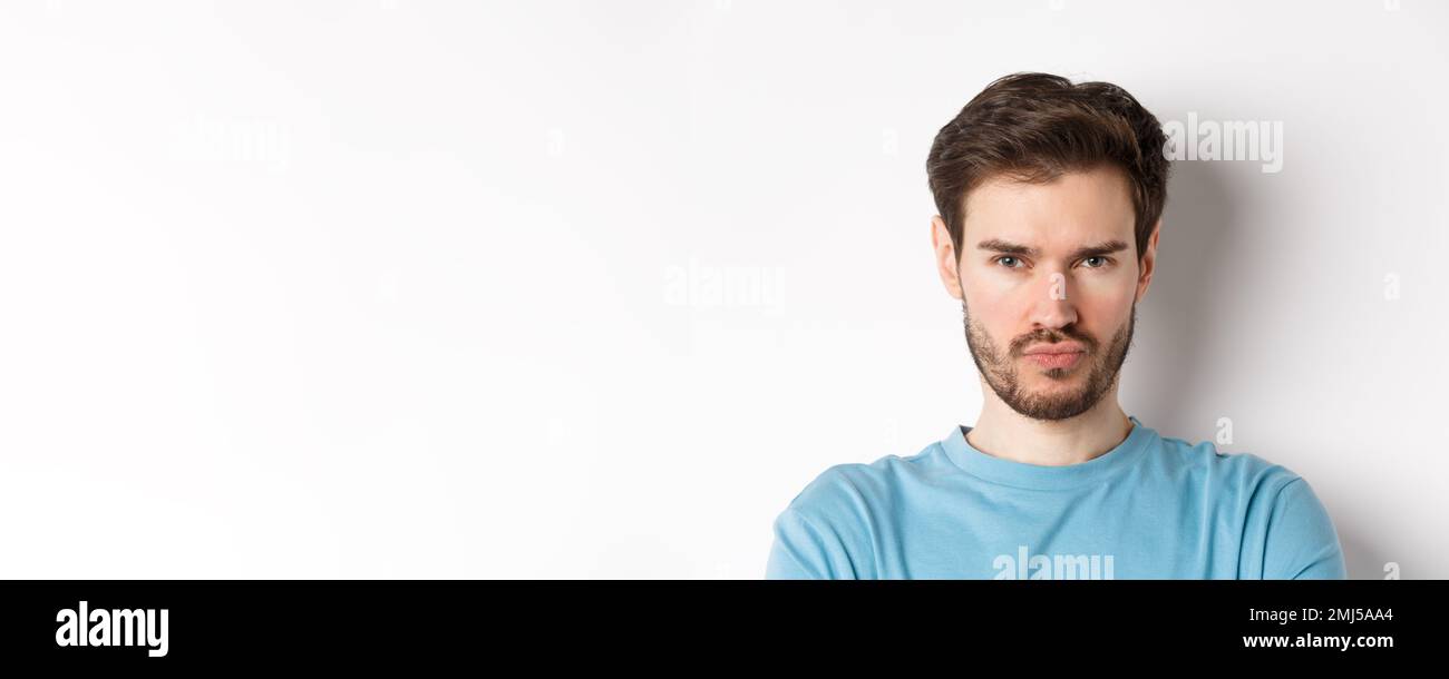 Close-up of grumpy young man grimacing, sulking and making offended ...