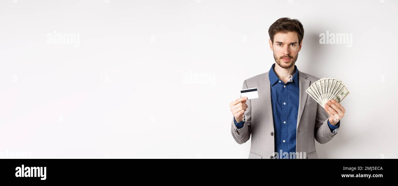 Successful businessman making money, standing in suit with dollar bills ...