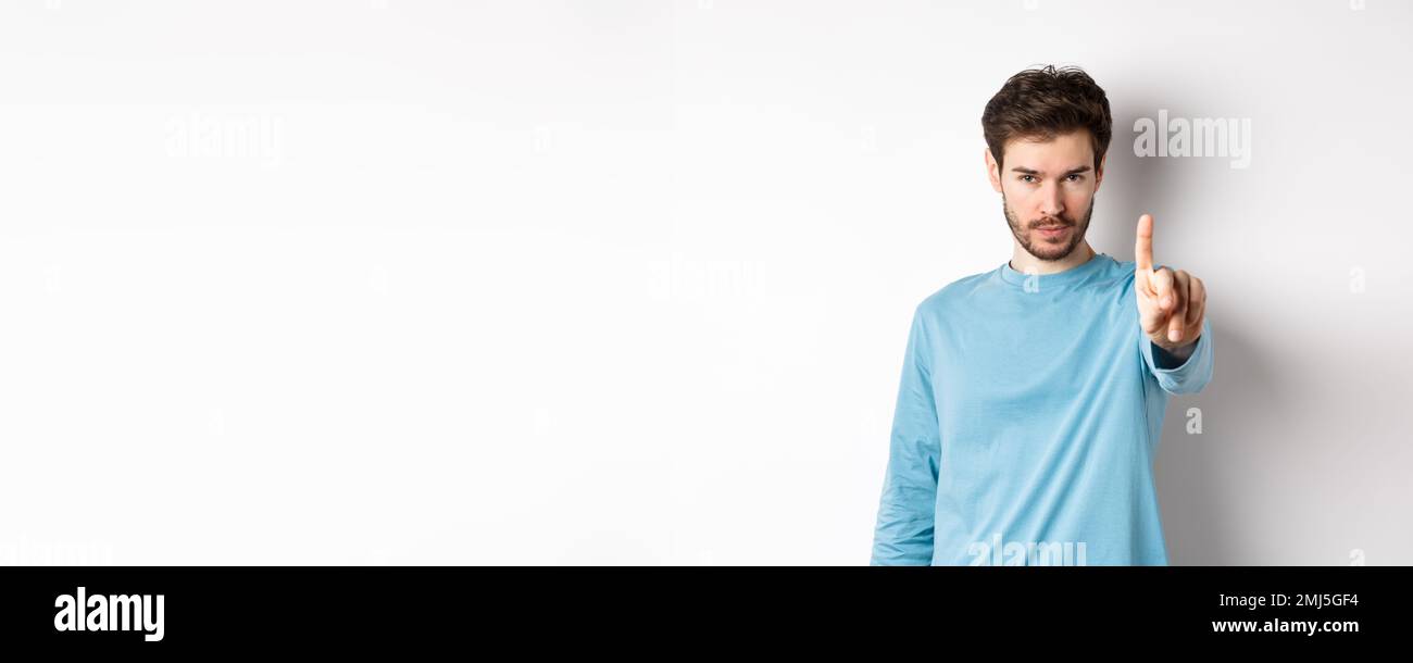 Image of serious young man with beard, shaking finger in disapproval ...