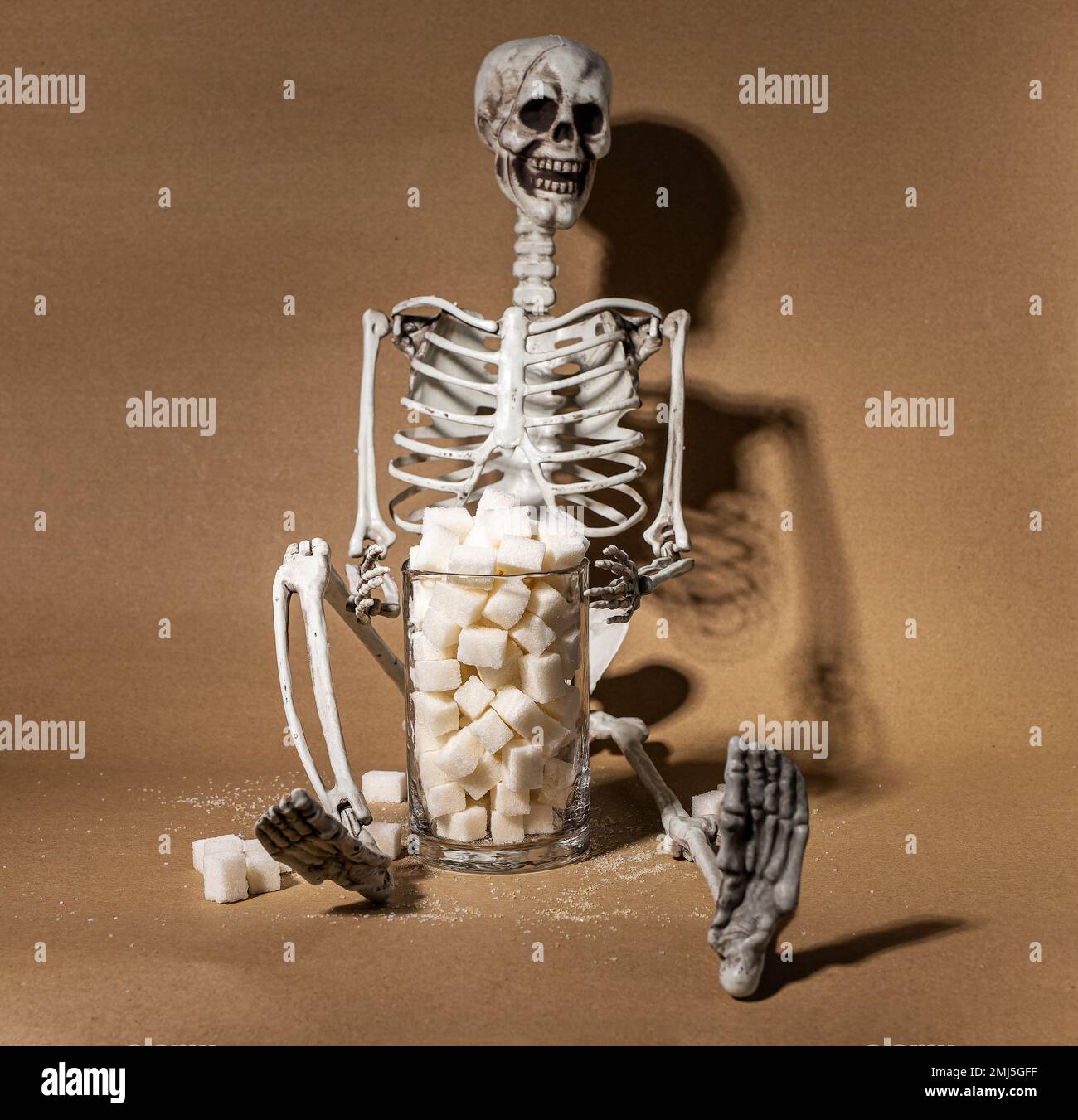 Eating lot of sugar consequence concept. Dead human skeleton with sweet ...
