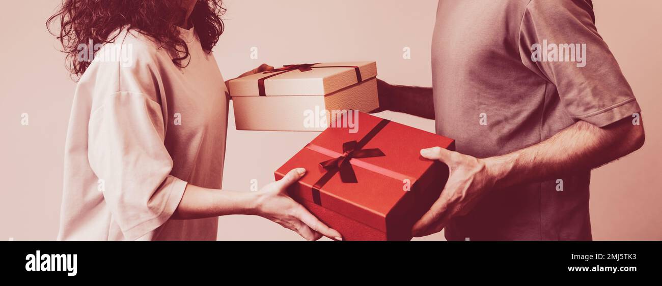 Valentine's Day concept, couple in love giving each other gifts in ...