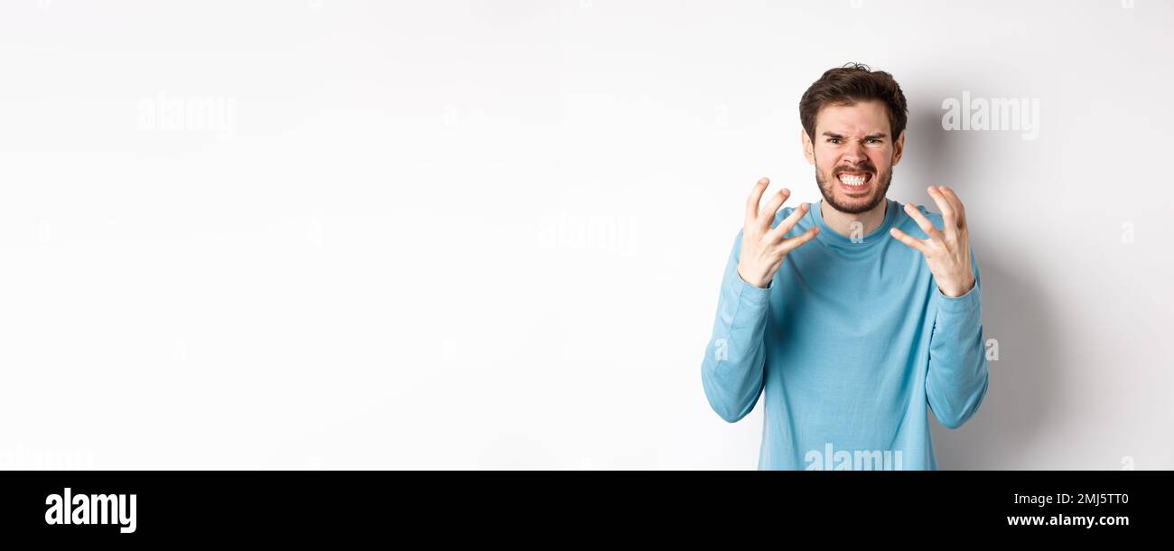 Angry caucasian man shaking hands and grimacing, looking with mad face ...