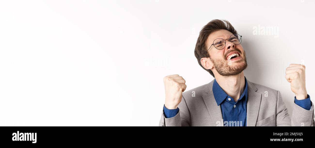Excited businessman in glasses and suit shouting yes with pleasure and ...