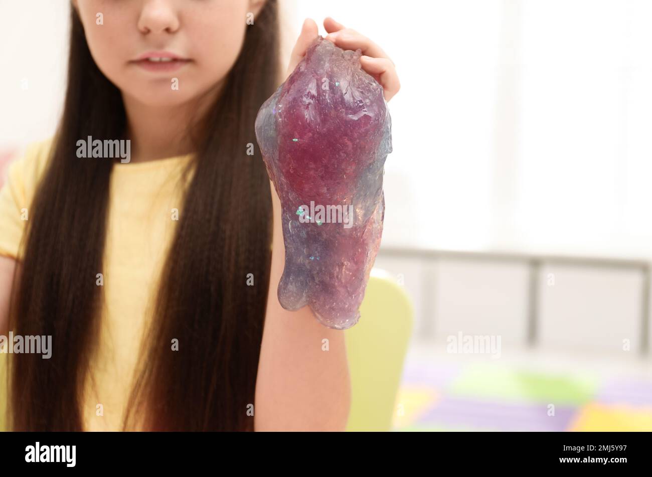 Little girl playing with slime in room, closeup Stock Photo - Alamy