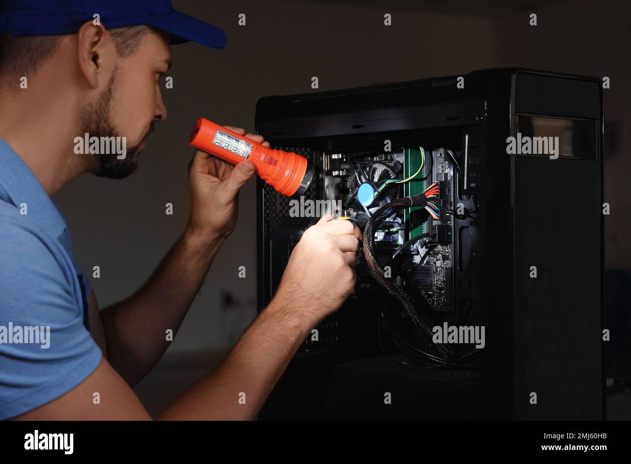 Repairman with flashlight fixing system unit indoors Stock Photo - Alamy