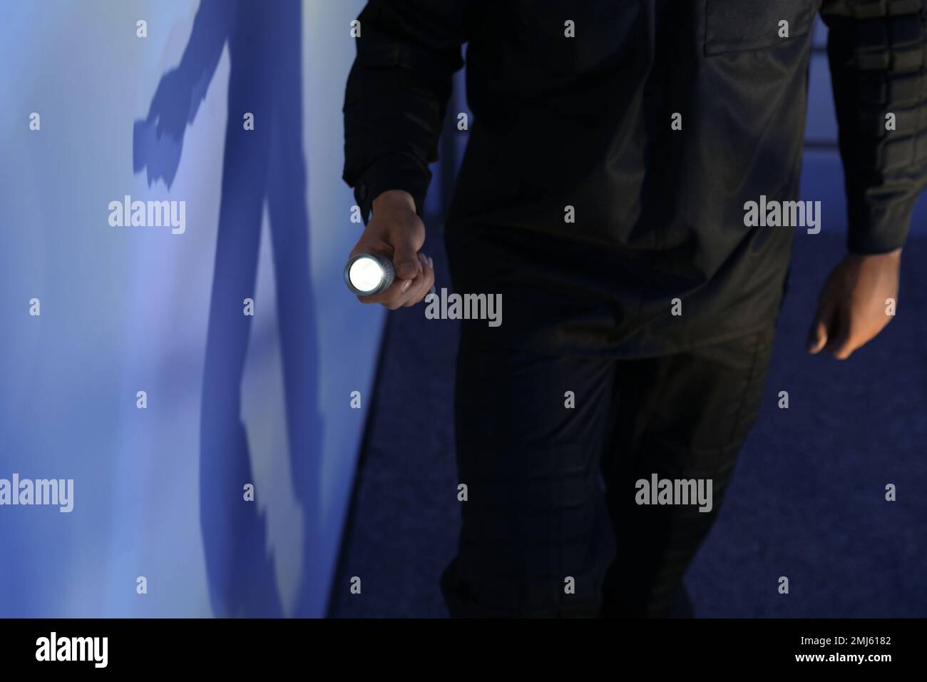 Male security guard with flashlight in dark room, closeup Stock Photo ...