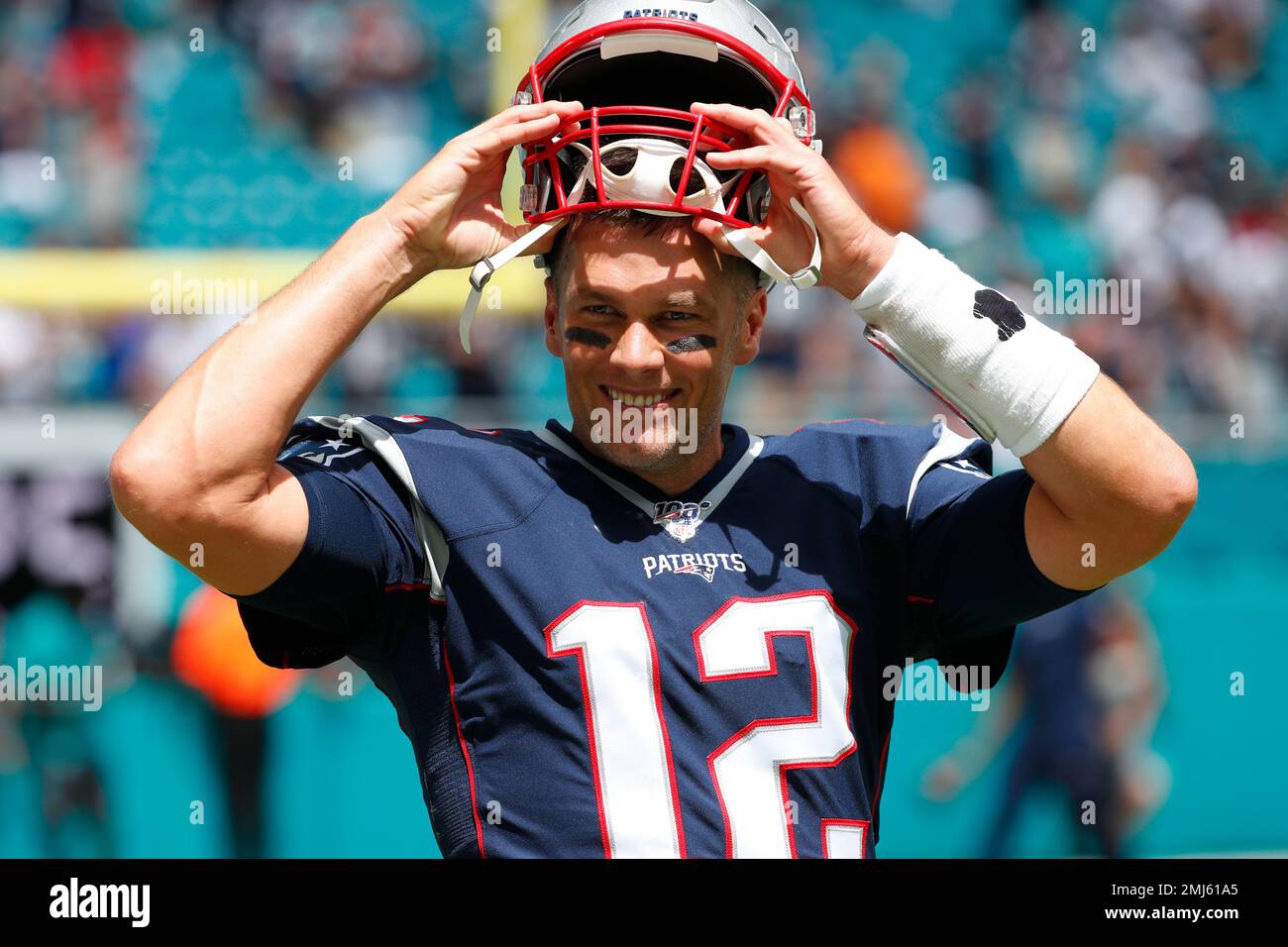 New England Patriots quarterback Tom Brady (12) smiles before an NFL ...