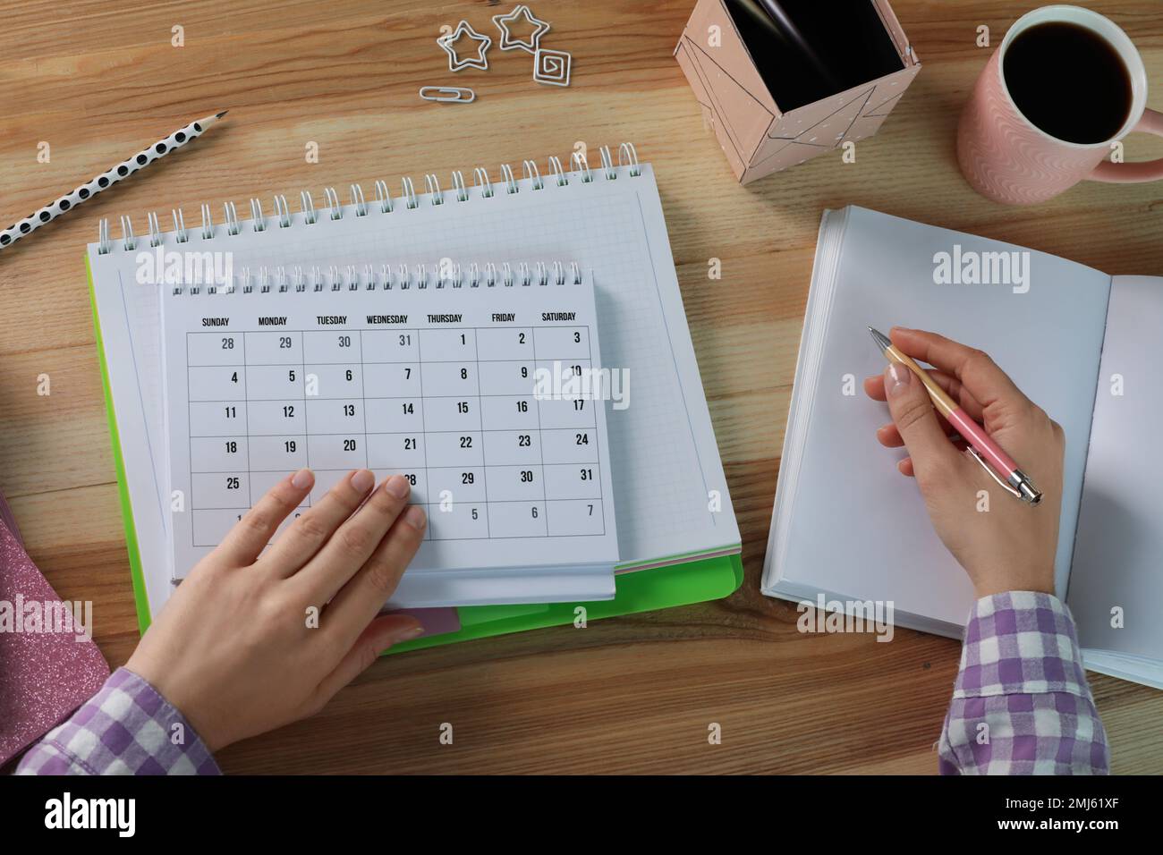 Woman making schedule using calendar at wooden table, top view Stock ...