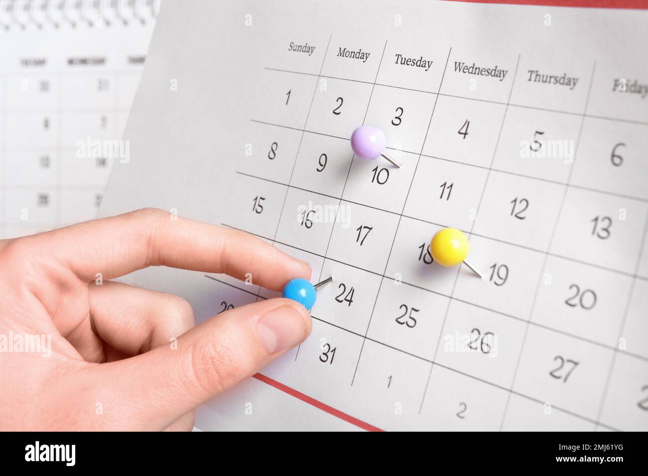 Woman marking date in calendar with drawing pin, closeup Stock Photo ...