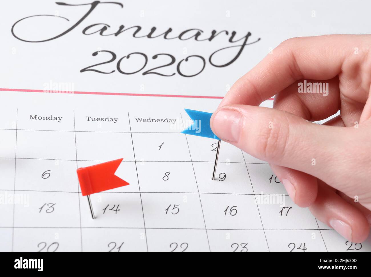 Woman marking date in calendar with drawing pin, closeup Stock Photo ...