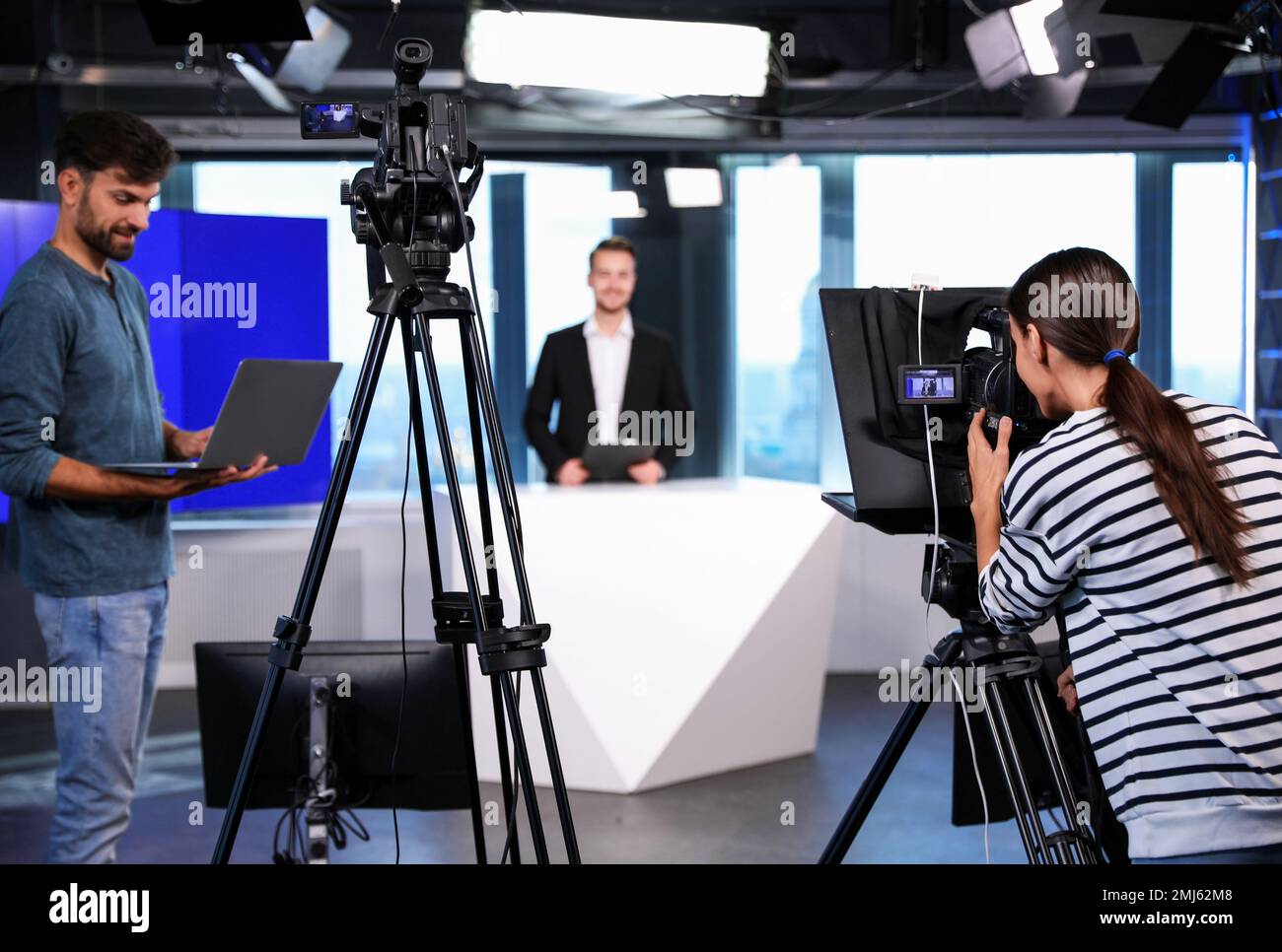Presenter, director and video camera operator working in studio. News ...