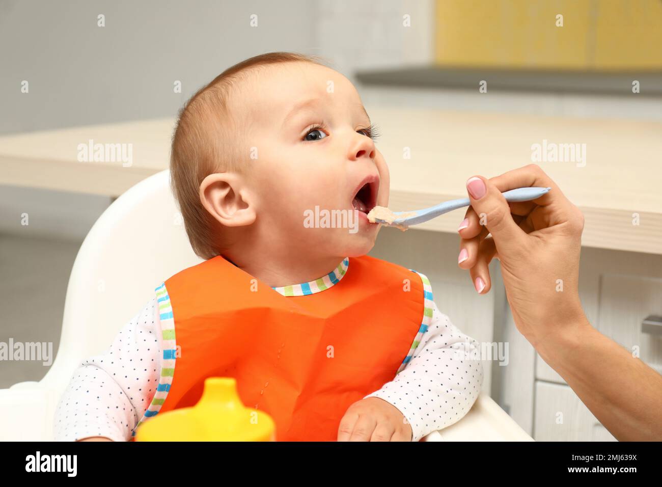 Young mother feeding her little baby at home Stock Photo - Alamy