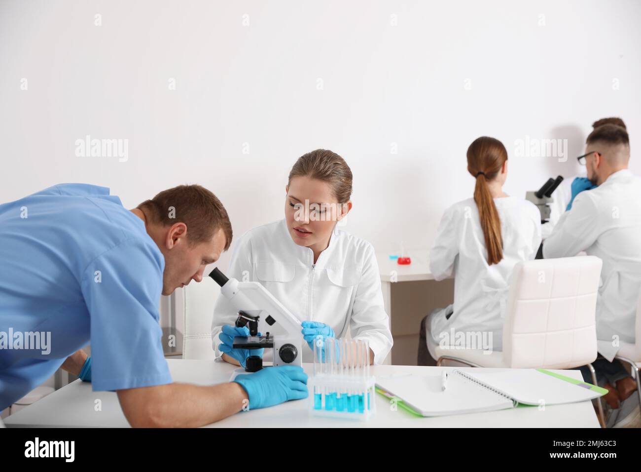 Medical students working with microscope in modern laboratory Stock ...