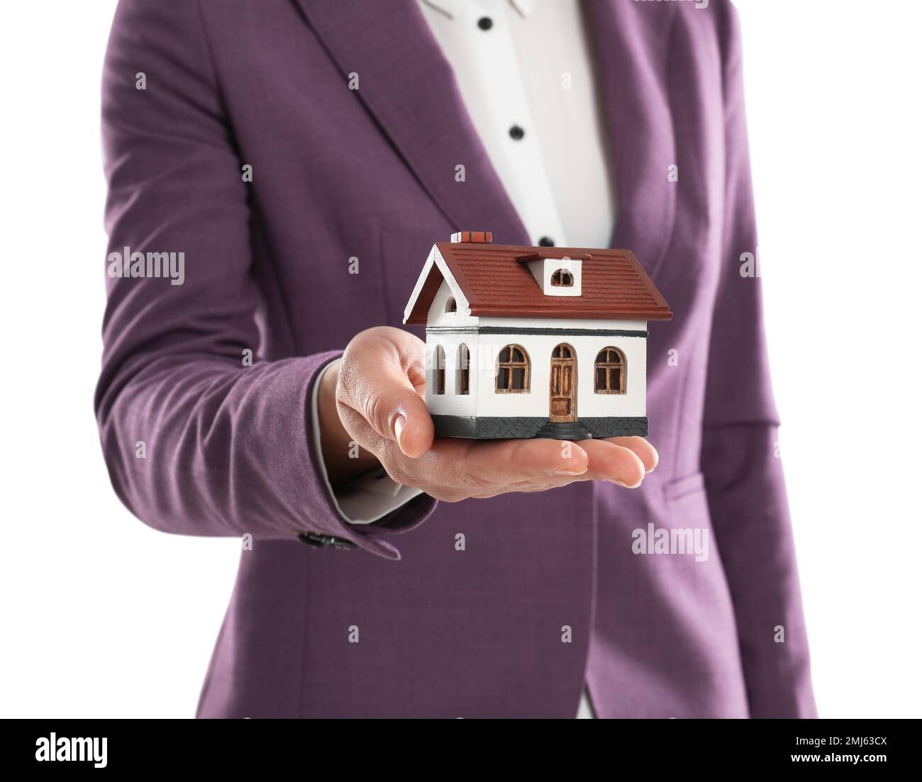 Real estate agent holding house model on white background, closeup ...