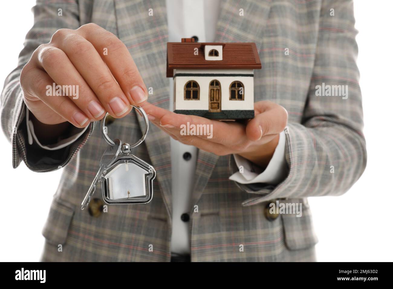 Real estate agent holding house model and key on white background ...