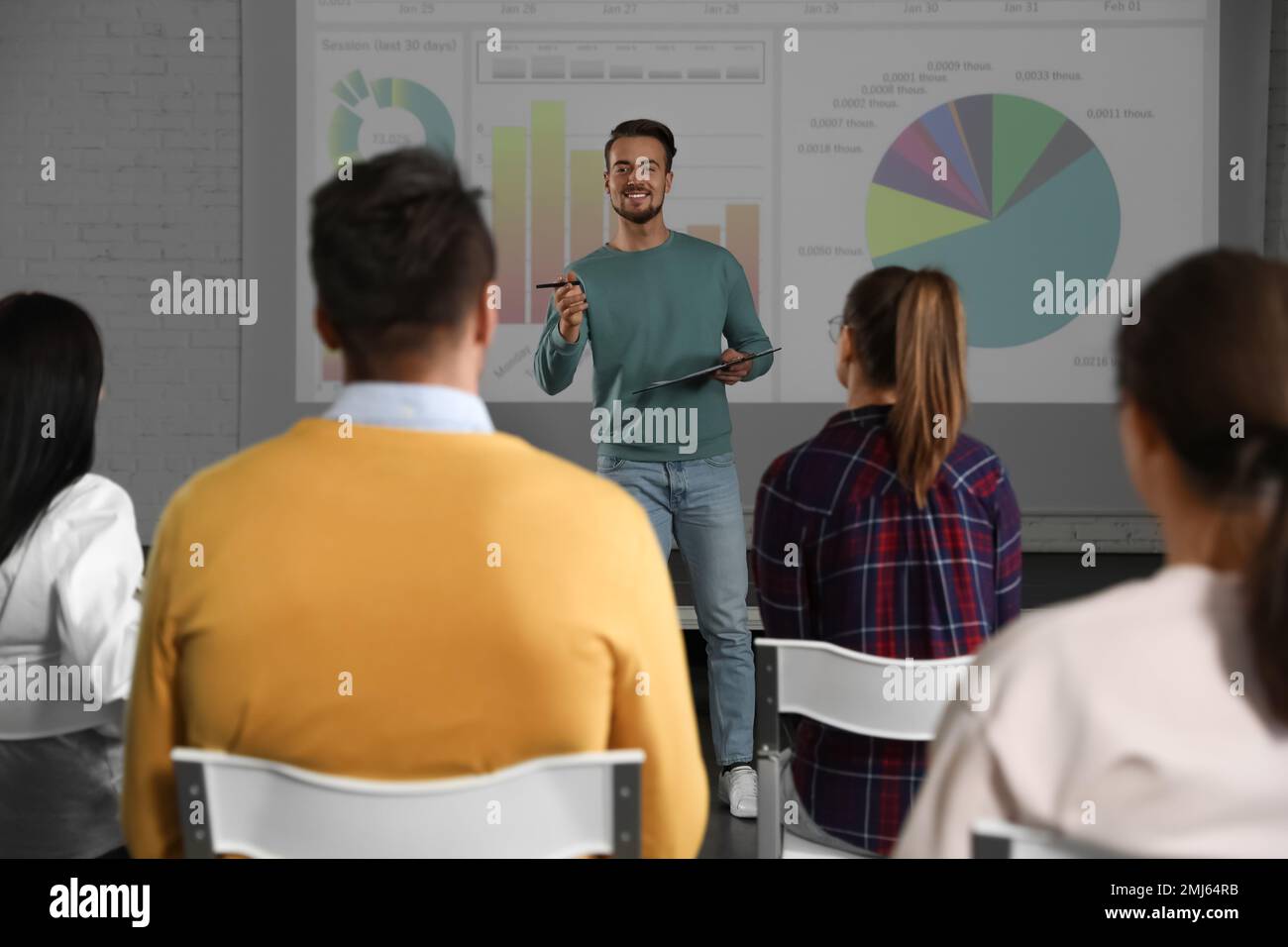 Male business trainer giving lecture in conference room with projection ...