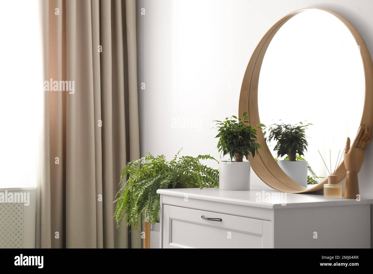 Round mirror and chest of drawers near white wall in room. Modern ...