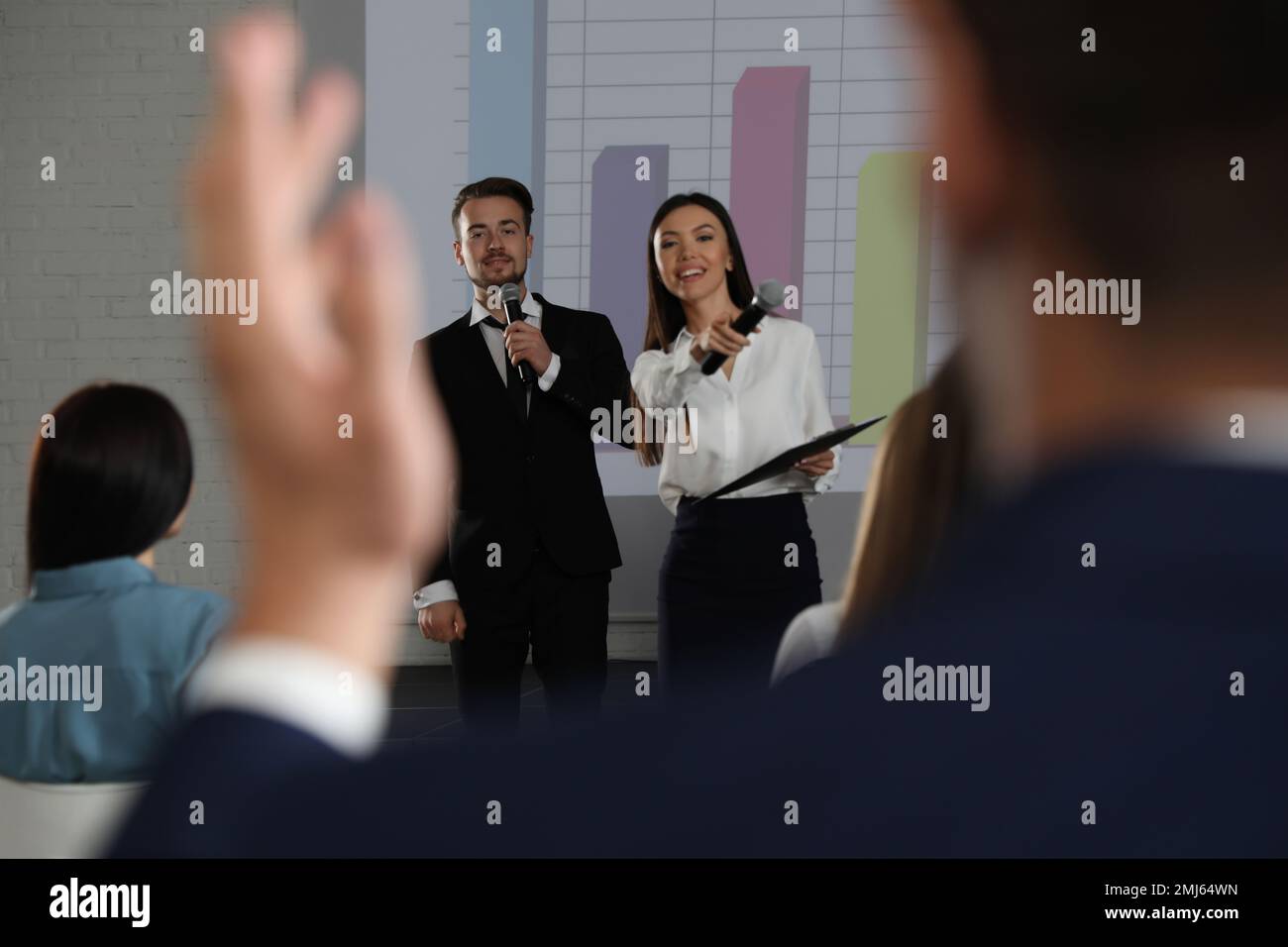 Business trainers giving lecture in conference room with projection ...