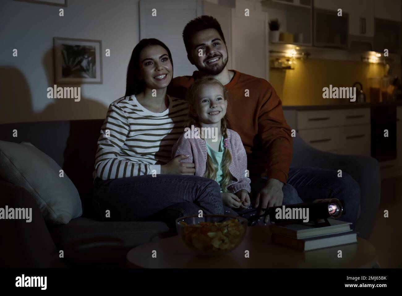 Family watching movie using video projector at home Stock Photo - Alamy