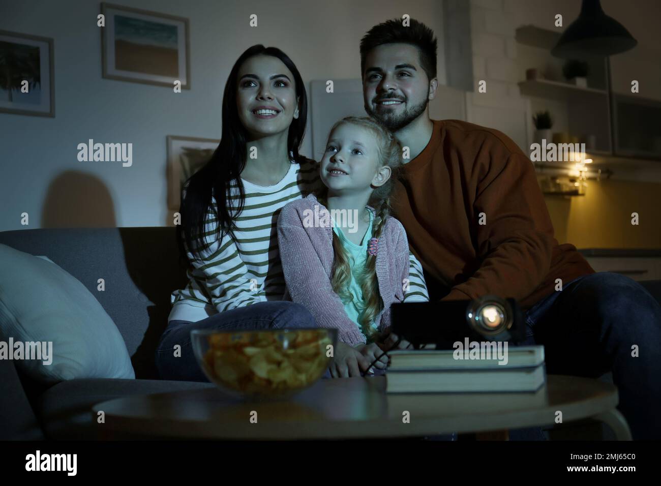 Family watching movie using video projector at home Stock Photo - Alamy