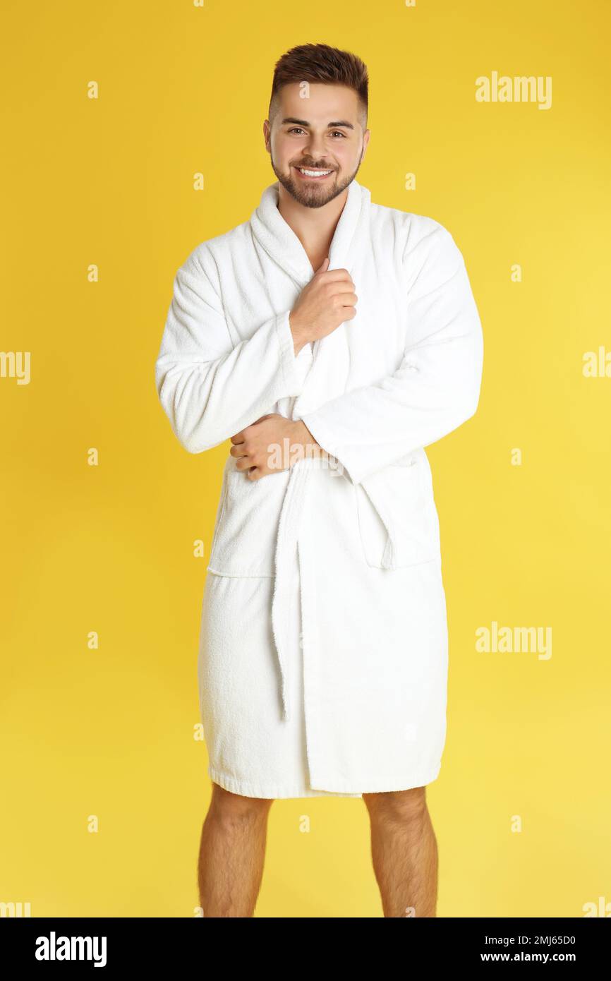 Happy young man in bathrobe on yellow background Stock Photo - Alamy
