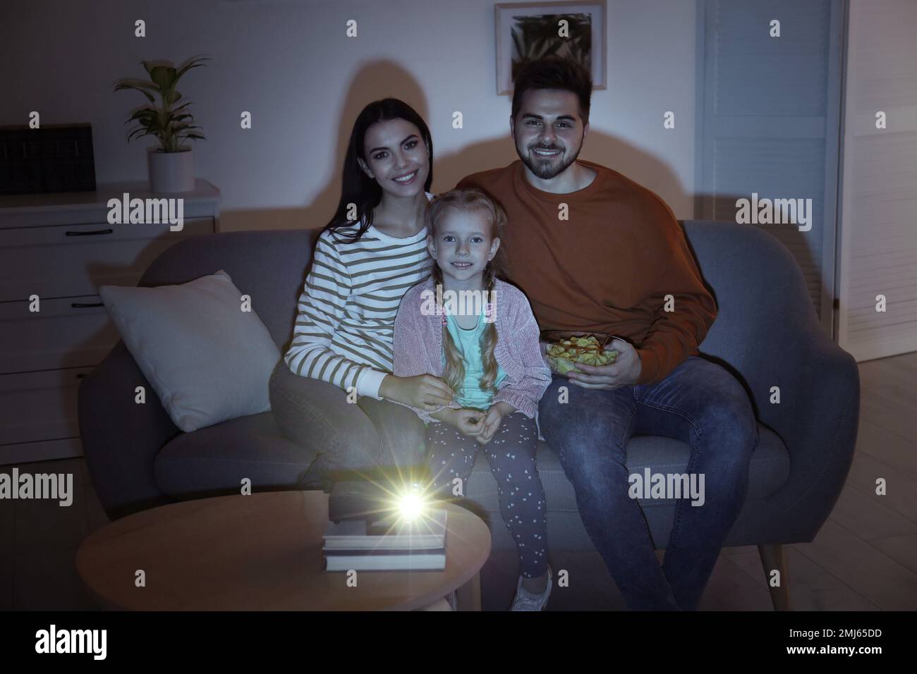 Family watching movie using video projector at home Stock Photo - Alamy