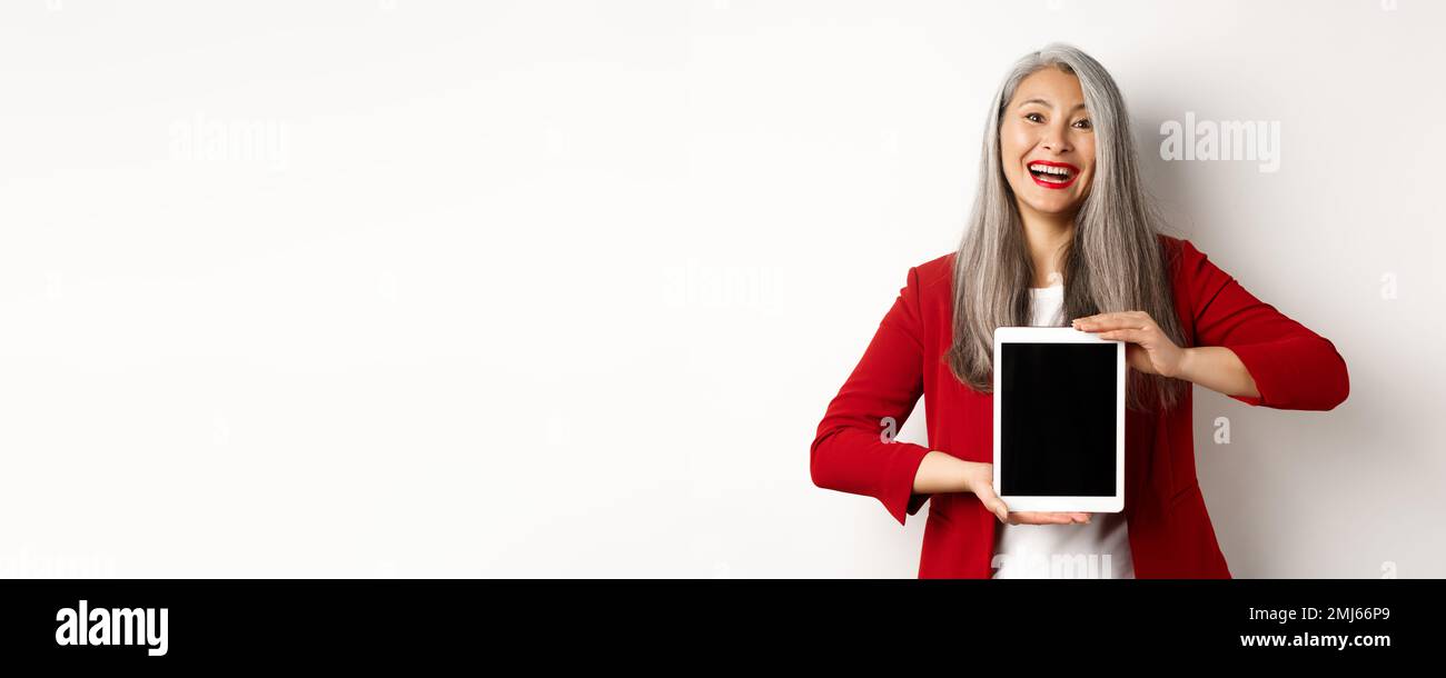 Business. Cheerful asian businesswoman in red blazer, showing digital ...