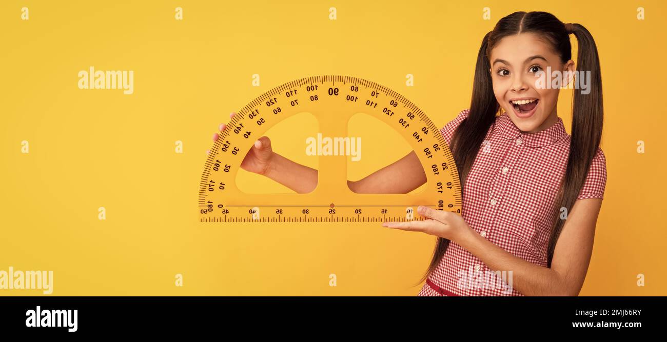 amazed kid hold school math tool protractor ruler on yellow background ...