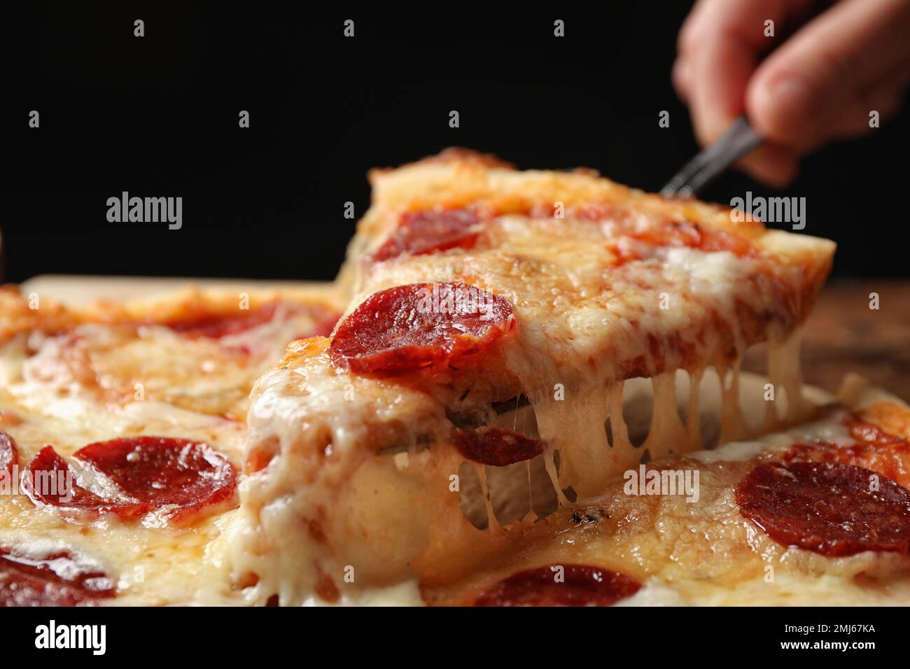 Woman taking slice of tasty pepperoni pizza at table, closeup Stock ...
