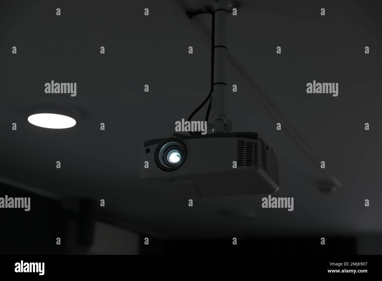 Modern video projector on ceiling in room Stock Photo - Alamy