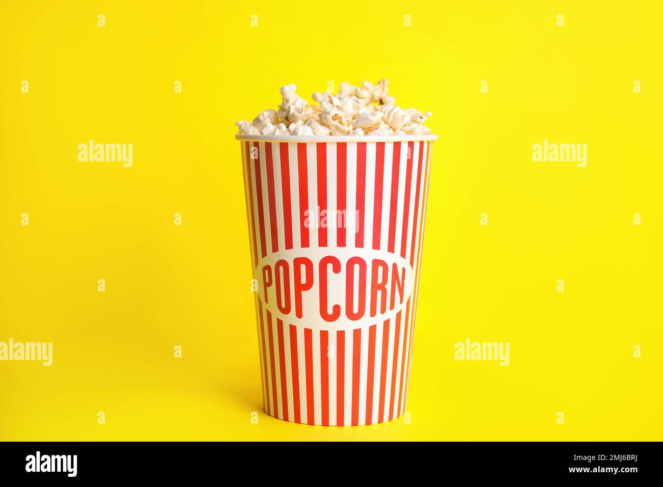 Tasty fresh pop corn on yellow background Stock Photo - Alamy