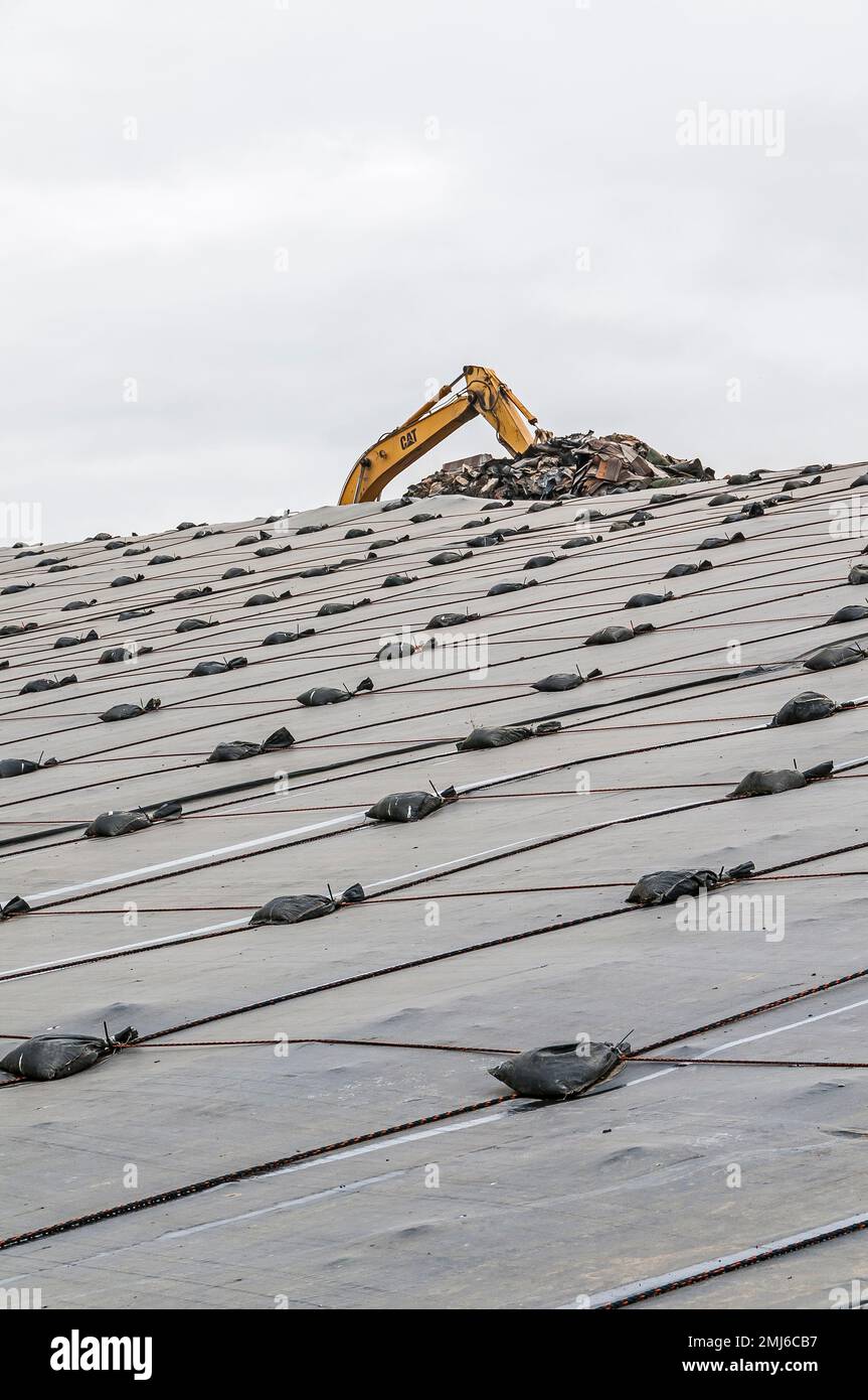 Weighted plastic sheeting covers a hillside in an active landfill ...