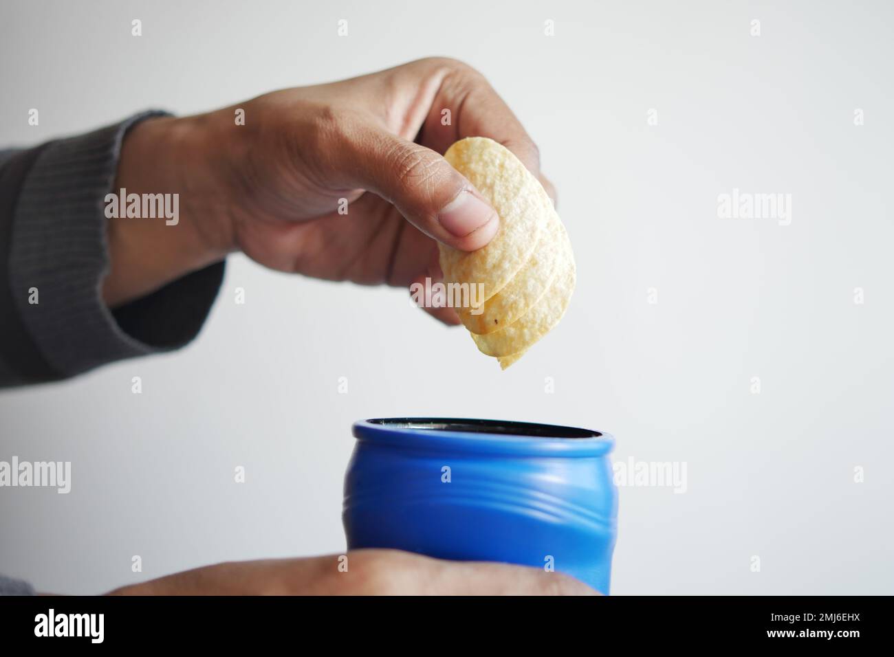 hand pick potato chips from a container Stock Photo - Alamy