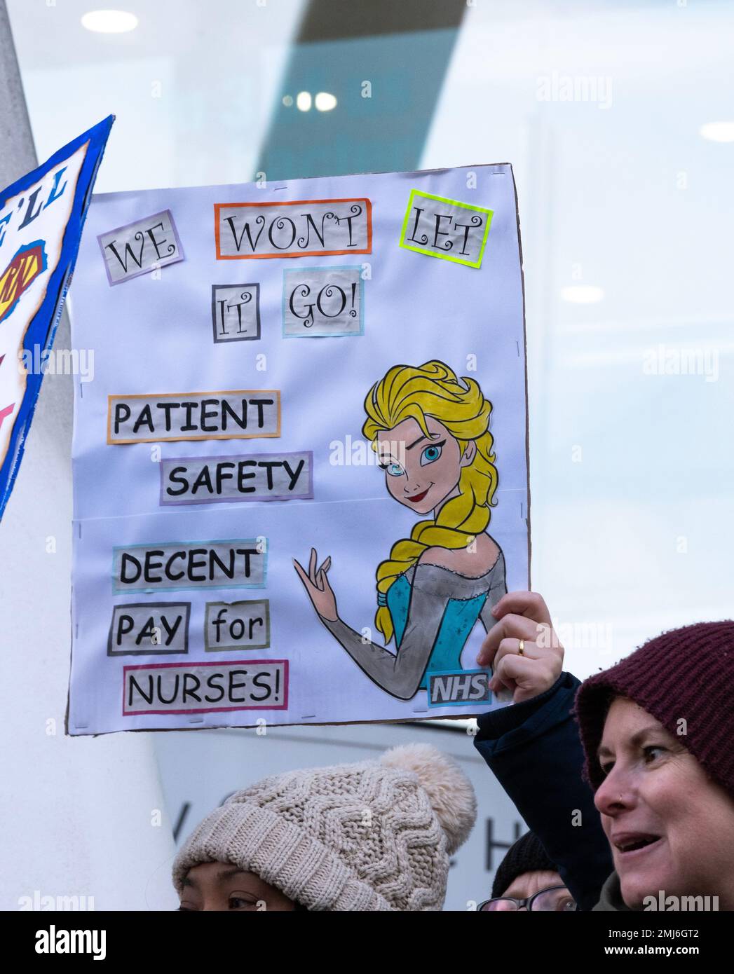 Striking nurses holding signs, demonstrating outside entrance of ...