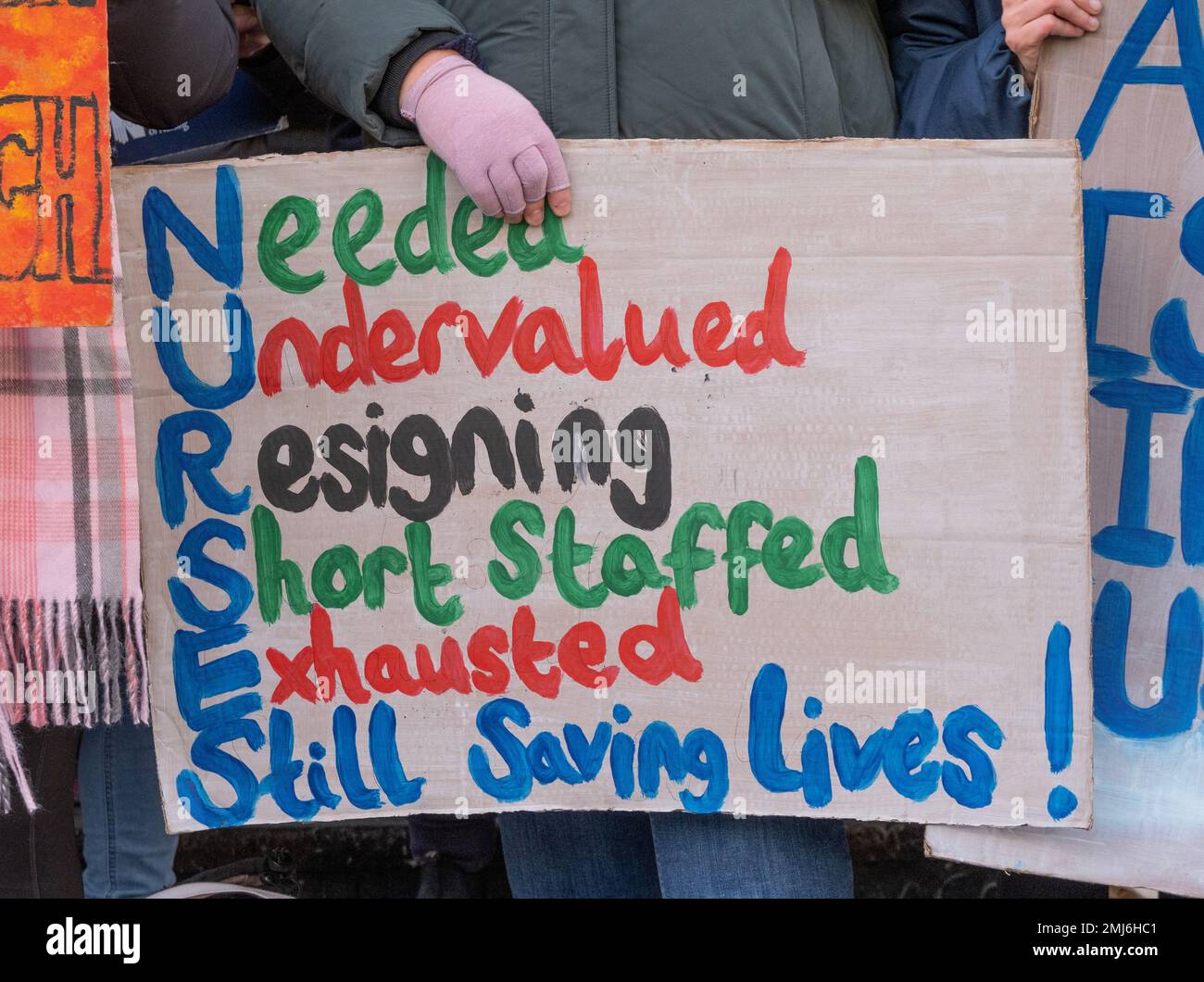 Striking nurses holding signs, demonstrating outside entrance of ...