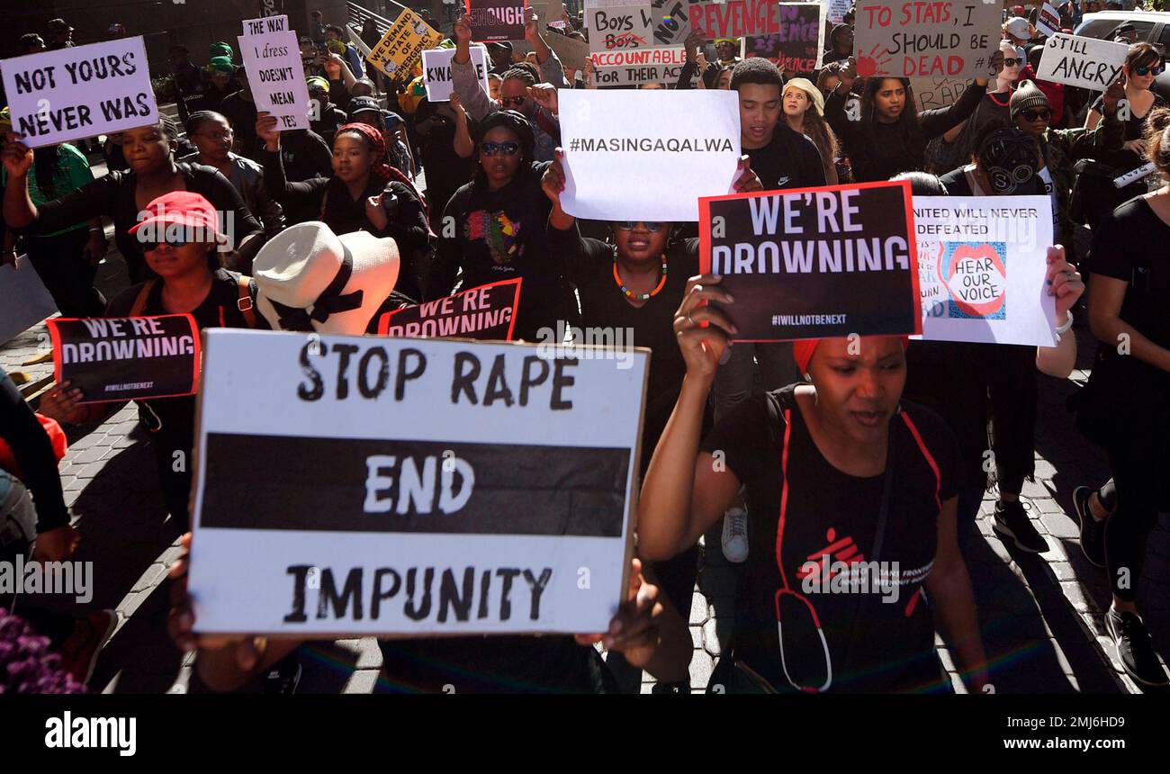 Demonstrators hold up banners in Sandton, Johannesburg, Friday Sept. 13 ...