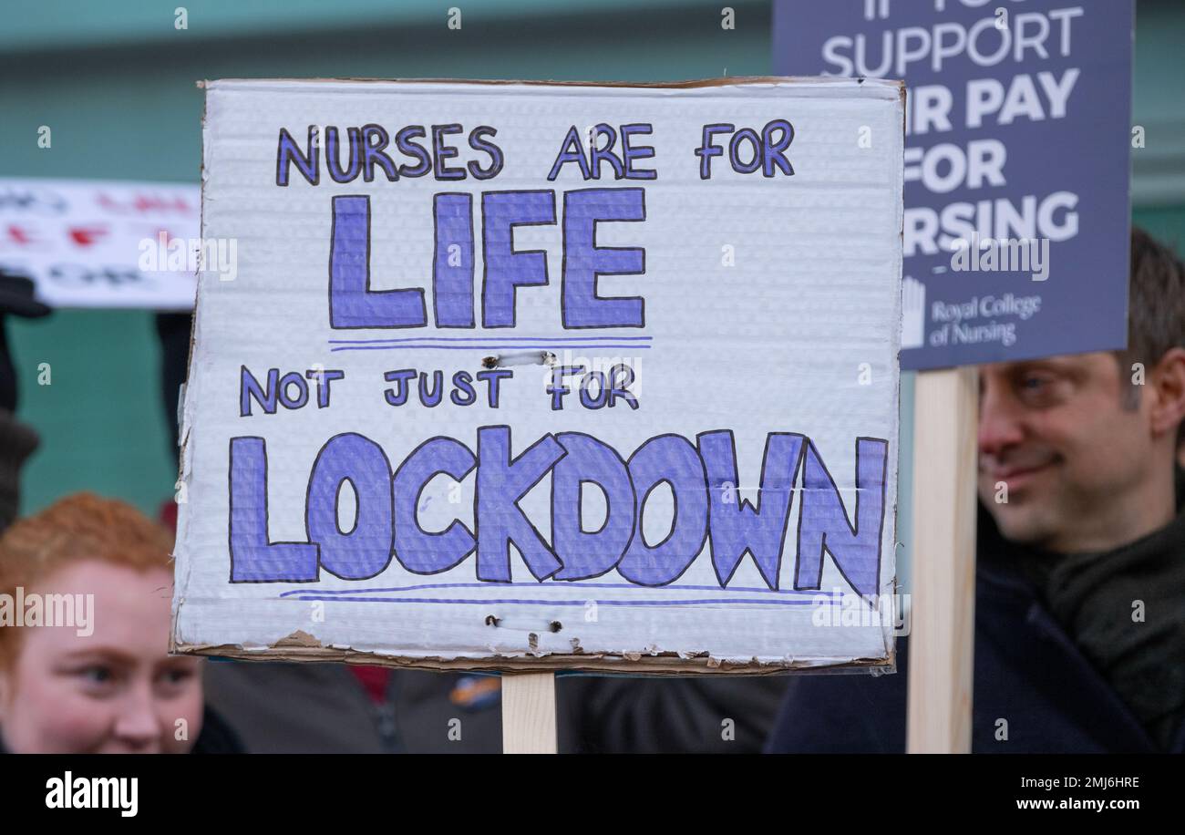 Striking nurses holding signs, demonstrating outside entrance of ...