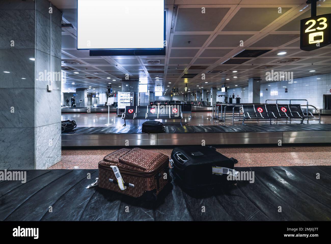 Several luggage wheeled suitcases are traveling on the baggage conveyor ...