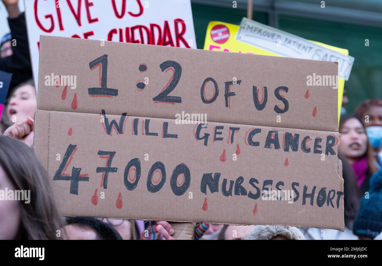 Striking nurses holding signs, demonstrating outside entrance of ...