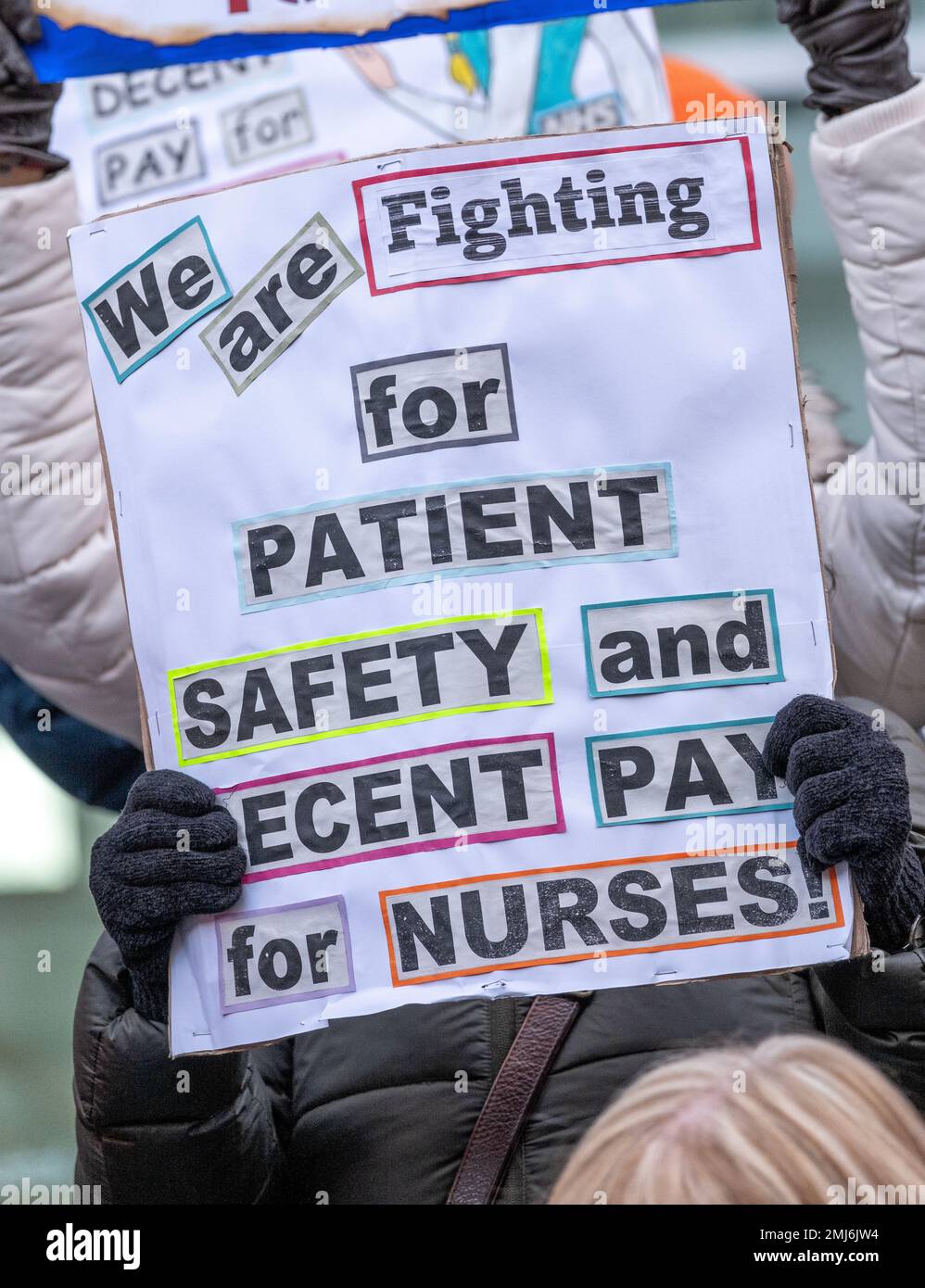 Striking nurses holding signs, demonstrating outside entrance of ...