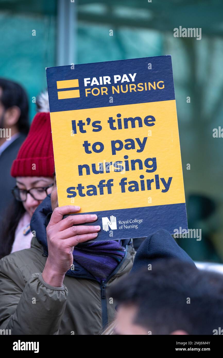 Striking nurses holding signs, demonstrating outside entrance of ...