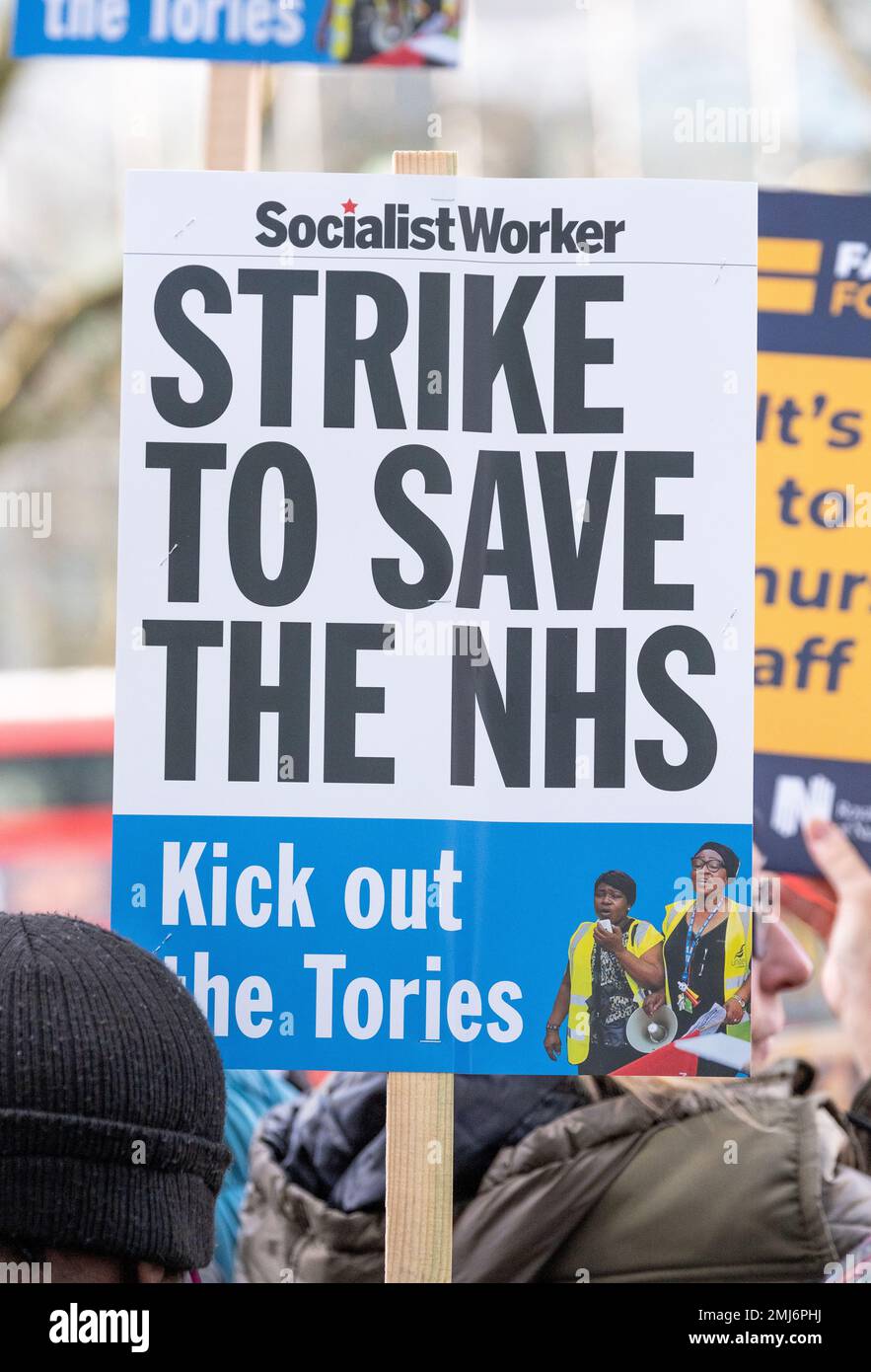 Striking nurses holding signs, demonstrating outside entrance of ...