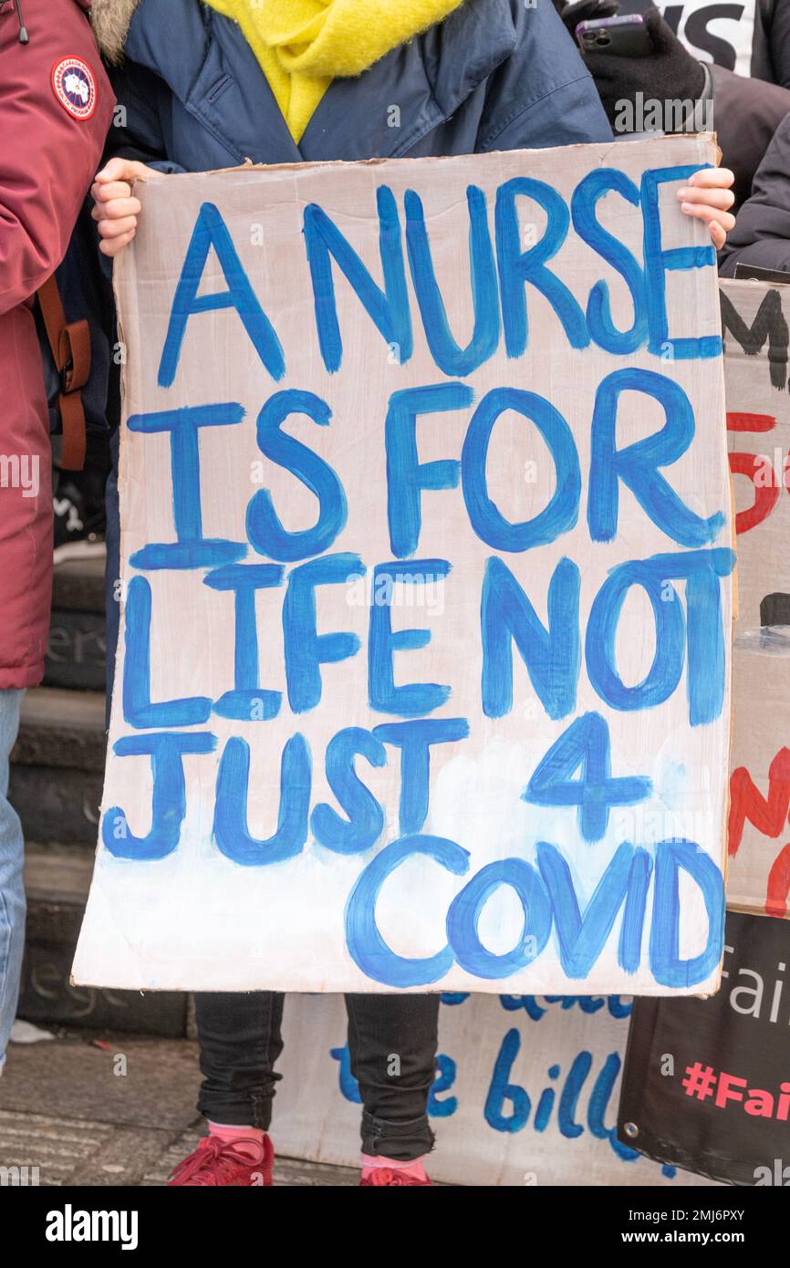 Striking nurses holding signs, demonstrating outside entrance of ...
