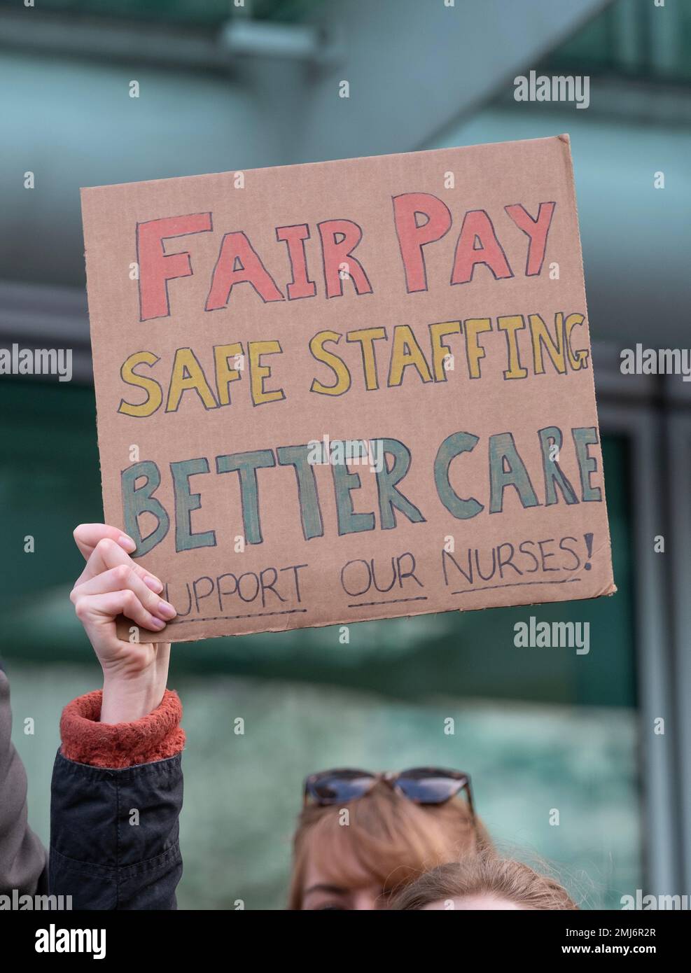 Striking nurses holding signs, demonstrating outside entrance of ...