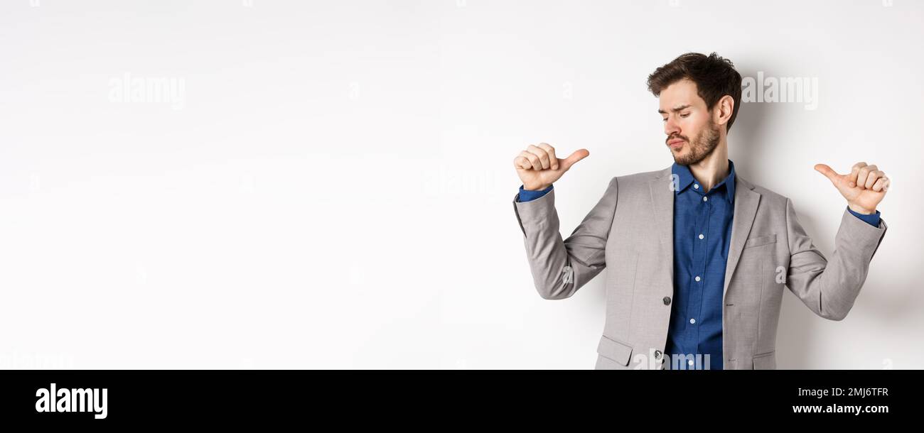 Handsome and confident man in suit pointing at himself, feeling cool ...