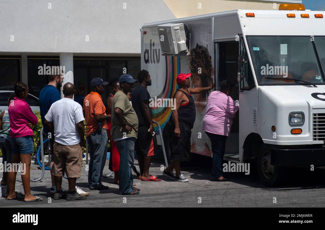 People line up to buy pre-paid cell phone cards, for sale from a mobile ...