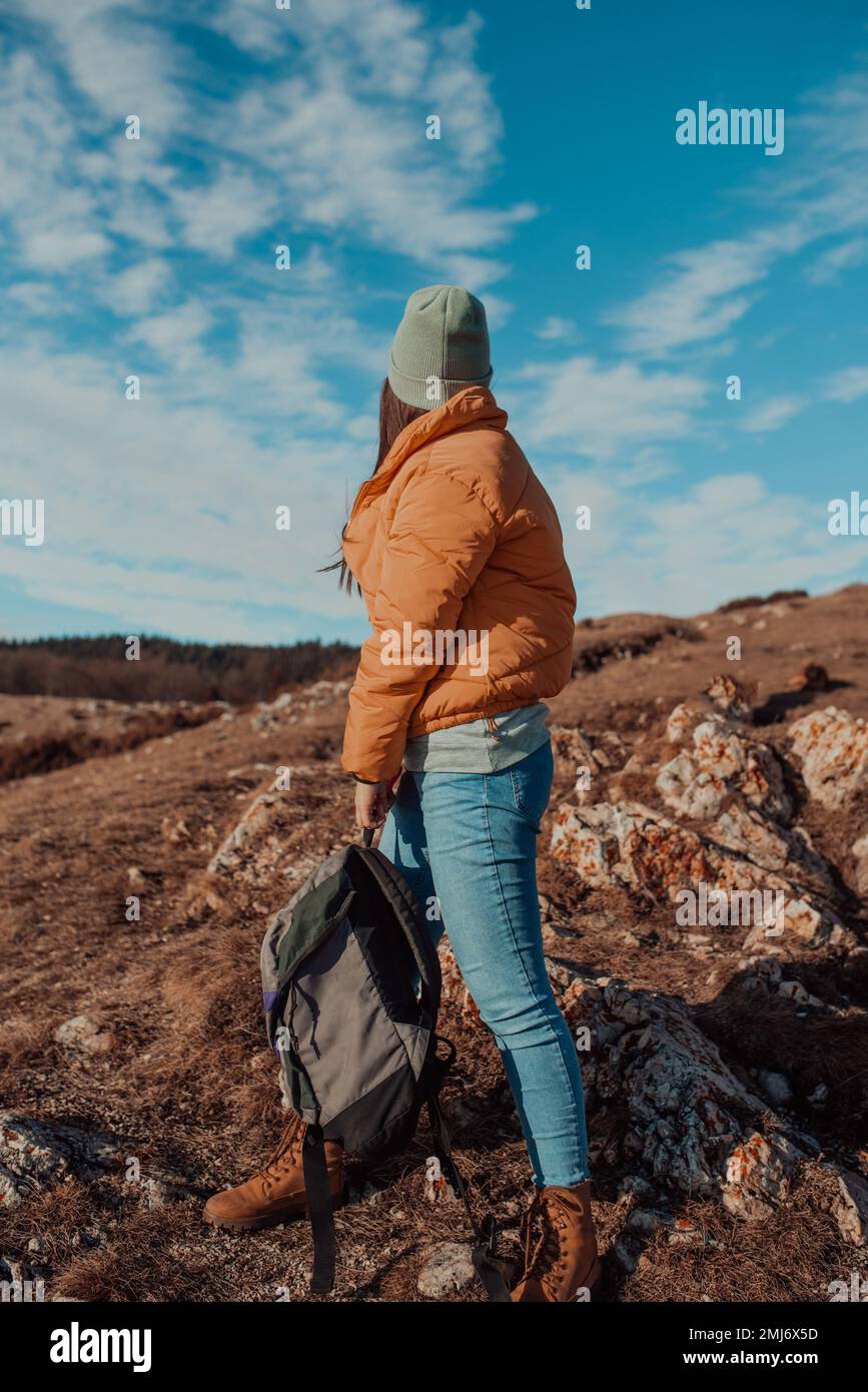 Cheering woman backpacker enjoy the view on sunrise mountain top cliff ...