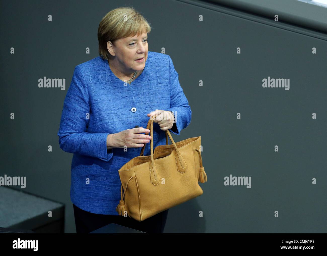 German Chancellor Angela Merkel holds her bag as she arrives for a ...