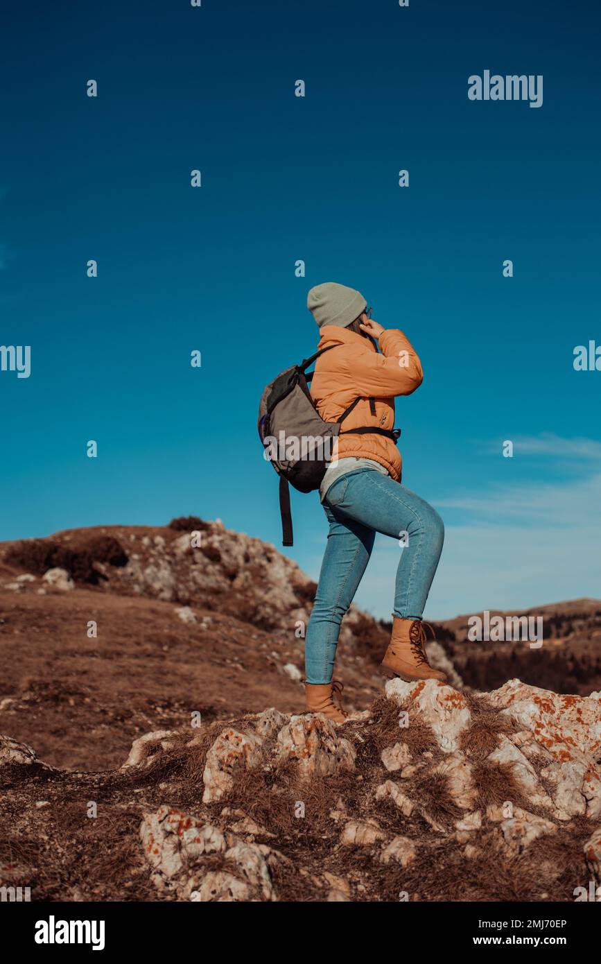 a hiking girl with a backpack on her back watches the morning from the ...